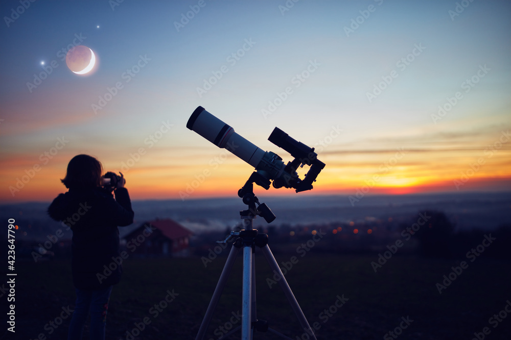 Child girl observing stars, planets, Moon and night sky with ...