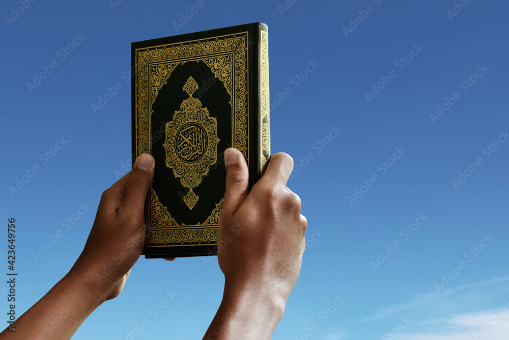 Religious muslim man holding holy quran Stock Photo | Adobe Stock