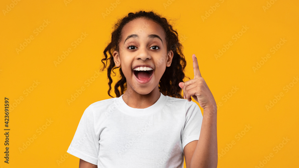 Excited black girl has great idea and points up Stock Photo | Adobe Stock