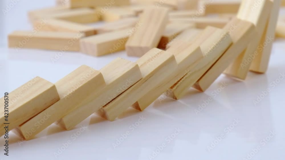 Domino effect, row of wooden domino falling down on white background ...