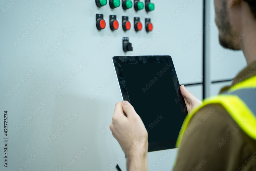 Electrical engineer working on the tablet and recording the voltage ...