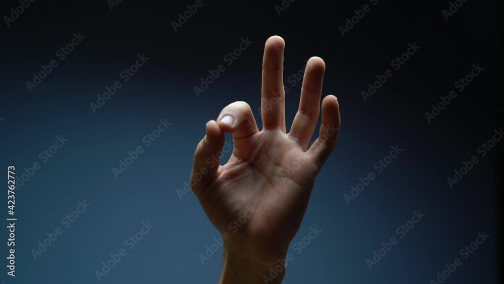 Unrecognizable male shows an ok sign on wall blue background. Hand sign ...