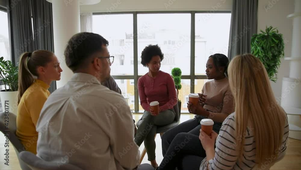Diverse group of people sitting in circle in group therapy session ...