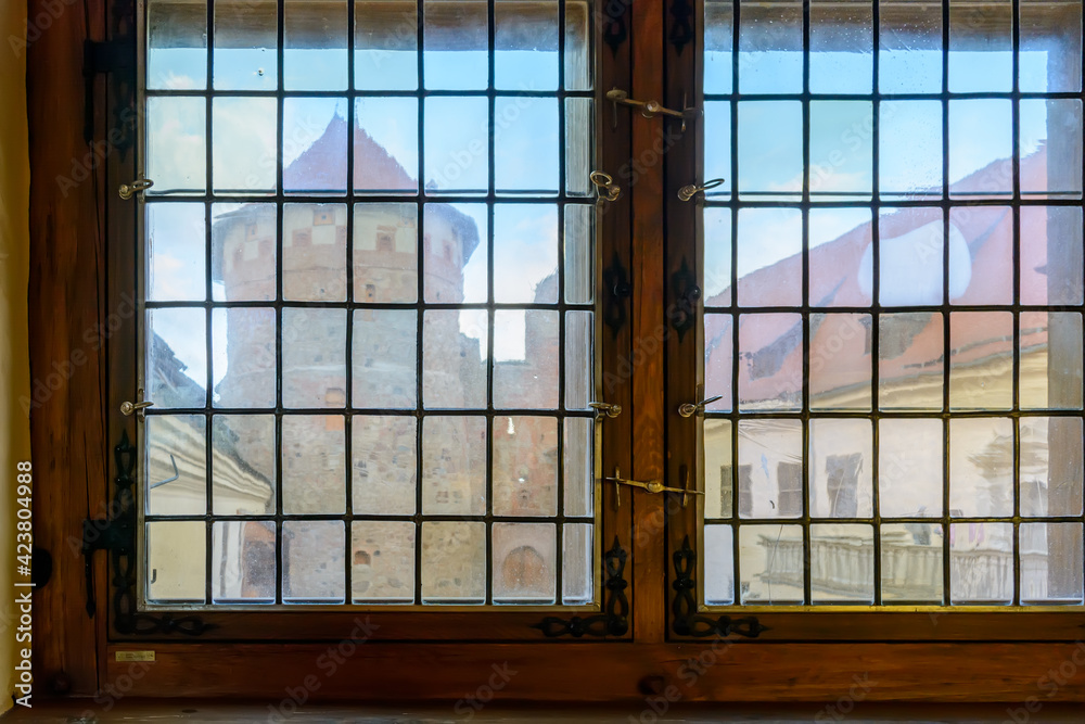 Ruins and tower of medieval castle through vintage stained-glass window ...