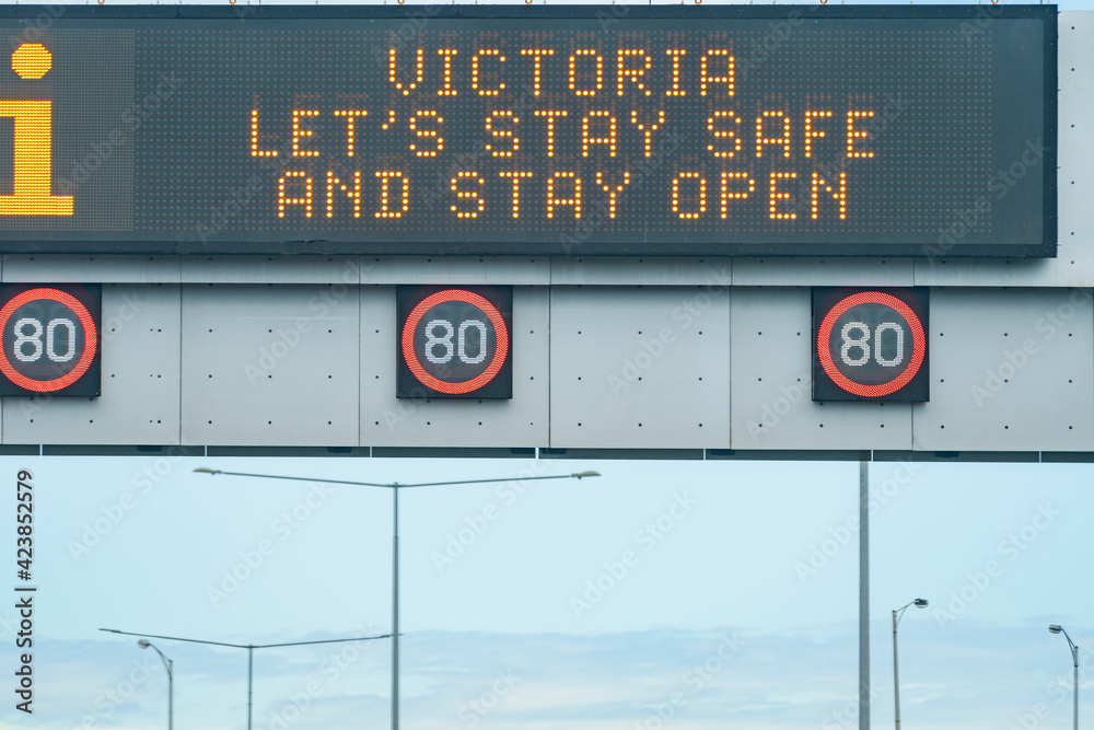 An overhead freeway sign promoting health and safety during the COVID ...