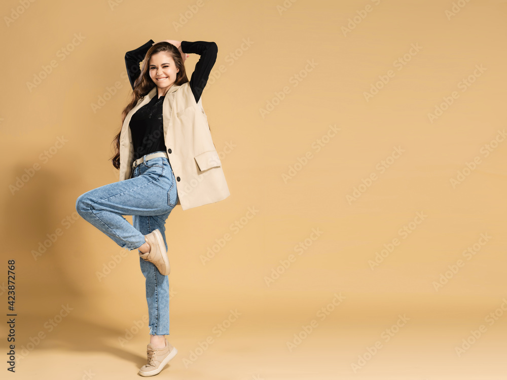 Young attractive girl with long curly hair posing standing on one leg ...