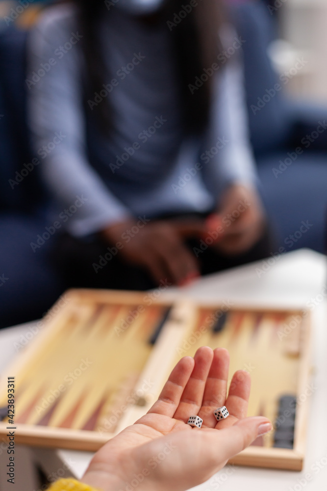 Cheerful happy woman using dice playing backgammon with multiethnic ...
