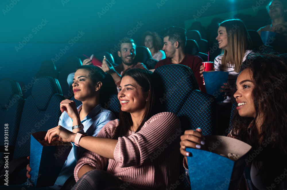 Foto de Group of cheerful people laughing while watching movie in ...