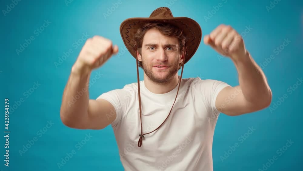 Attractive shocked young man in cowboy hat, extremely happy, with wide ...