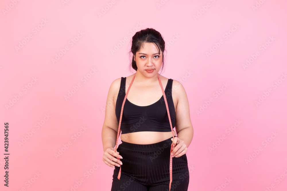 Fat woman with body measures the isolated pink background. Overweight ...