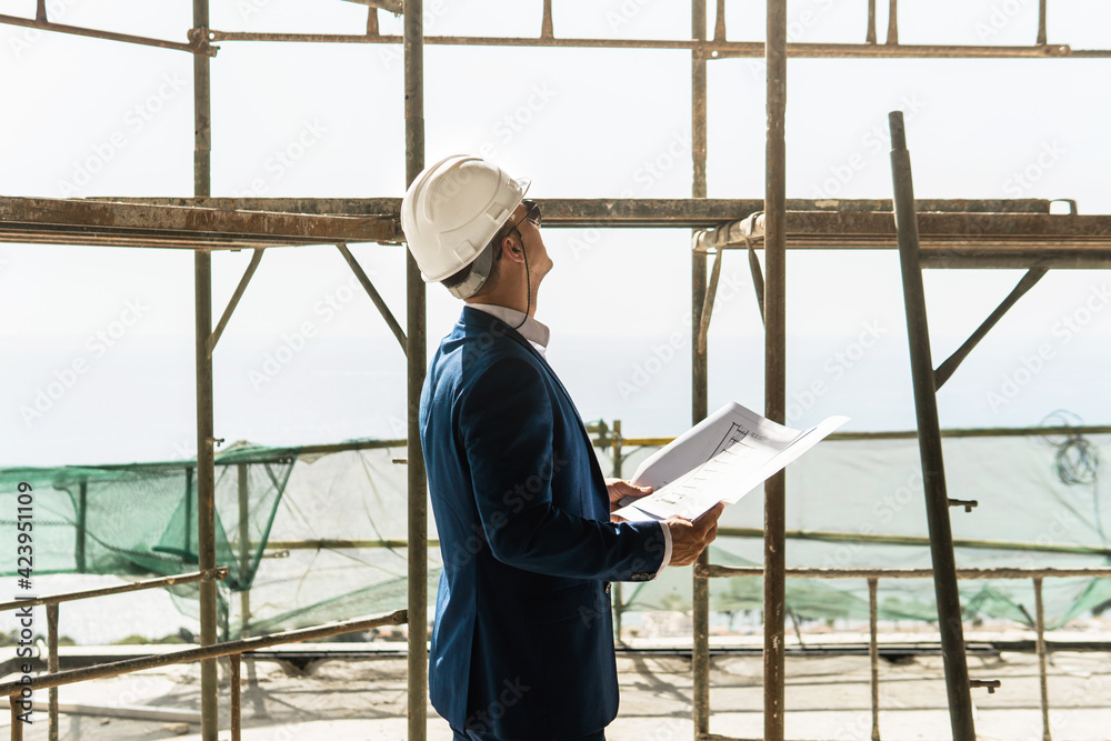 Man architect wearing formal suit and hard hat during building ...