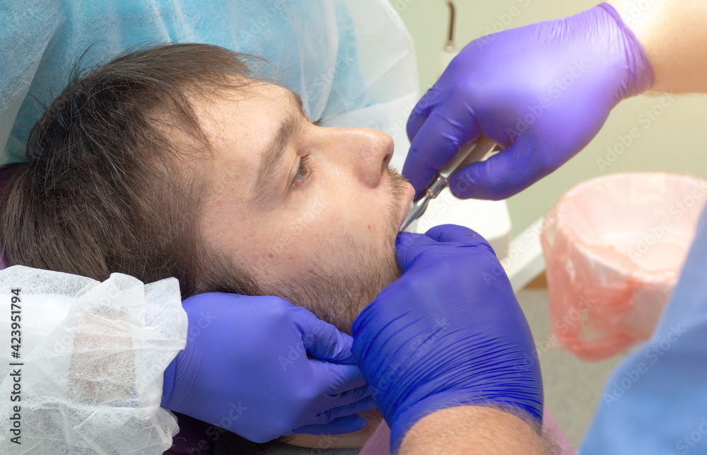 Team of dental surgeons performs surgery on teeth. in a modern clinic ...