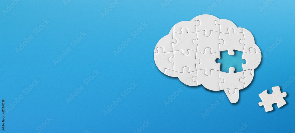 Brain shaped white jigsaw puzzle with copy space on blue background, a ...