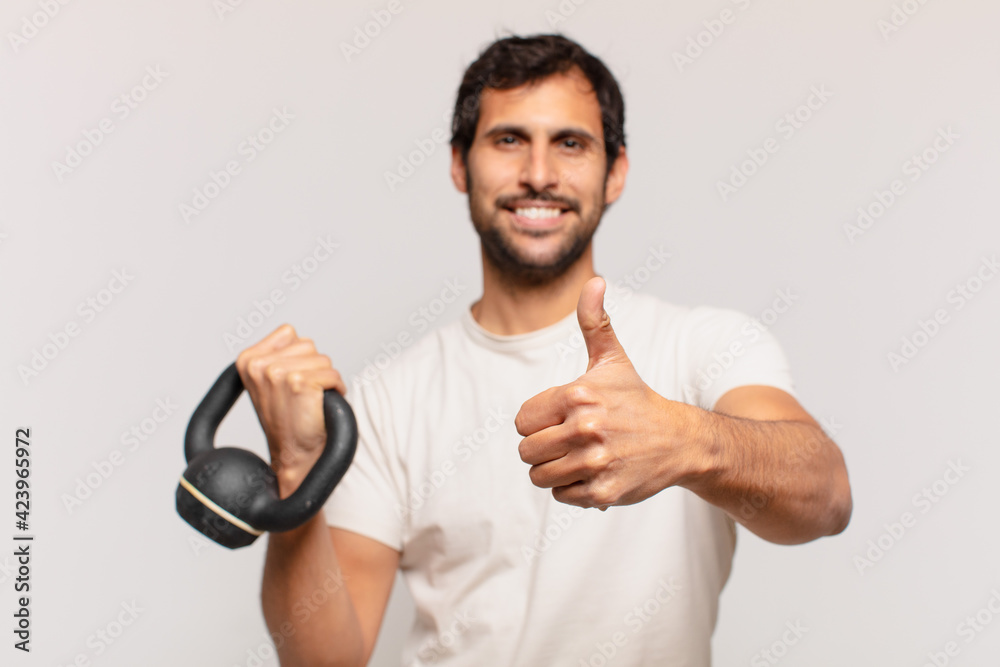 young handsome indian man happy expression and lifting a dumbbell Stock ...