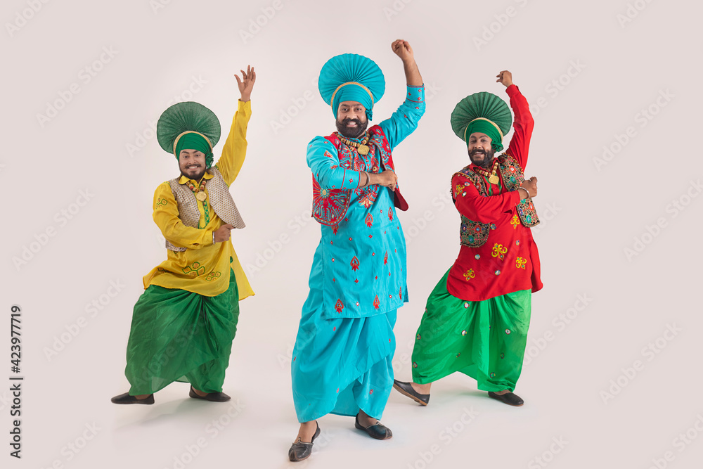 Three Bhangra dancers performing a dance step with hand gestures. Stock ...