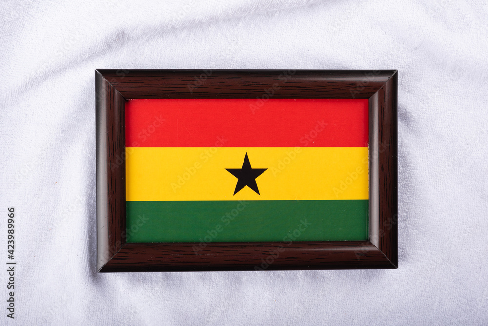 Ghana flag in a realistic frame on white cloth background flat lay ...