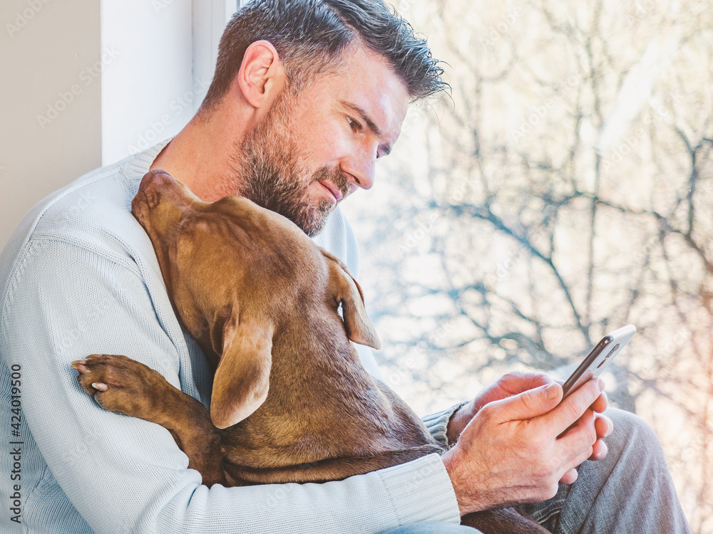 Handsome man and a charming puppy. Close-up, indoors. Studio photo ...