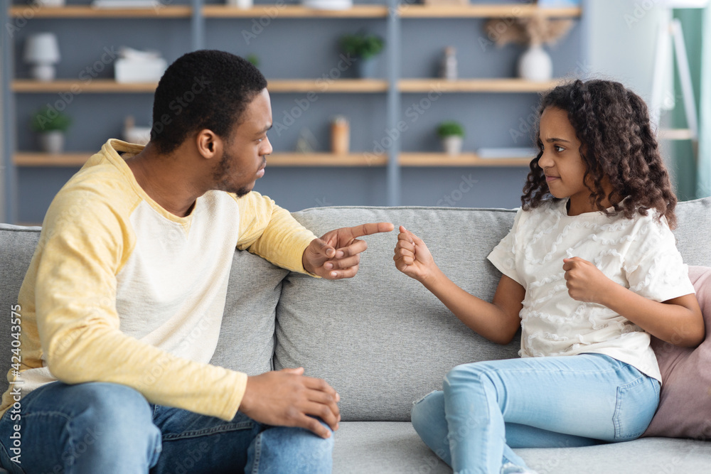 Serious black father scolding his angry daughter, home interior Stock ...