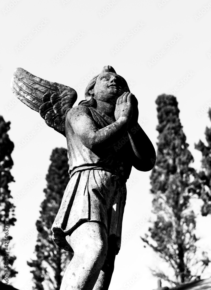 Praying Stone angel statue in a lonely cemetery Stock Photo | Adobe Stock