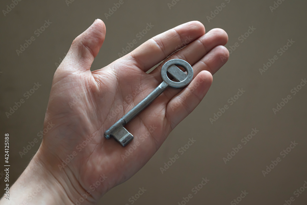 Old fashioned key held in a palm. Antique skeleton key symbolizing ...
