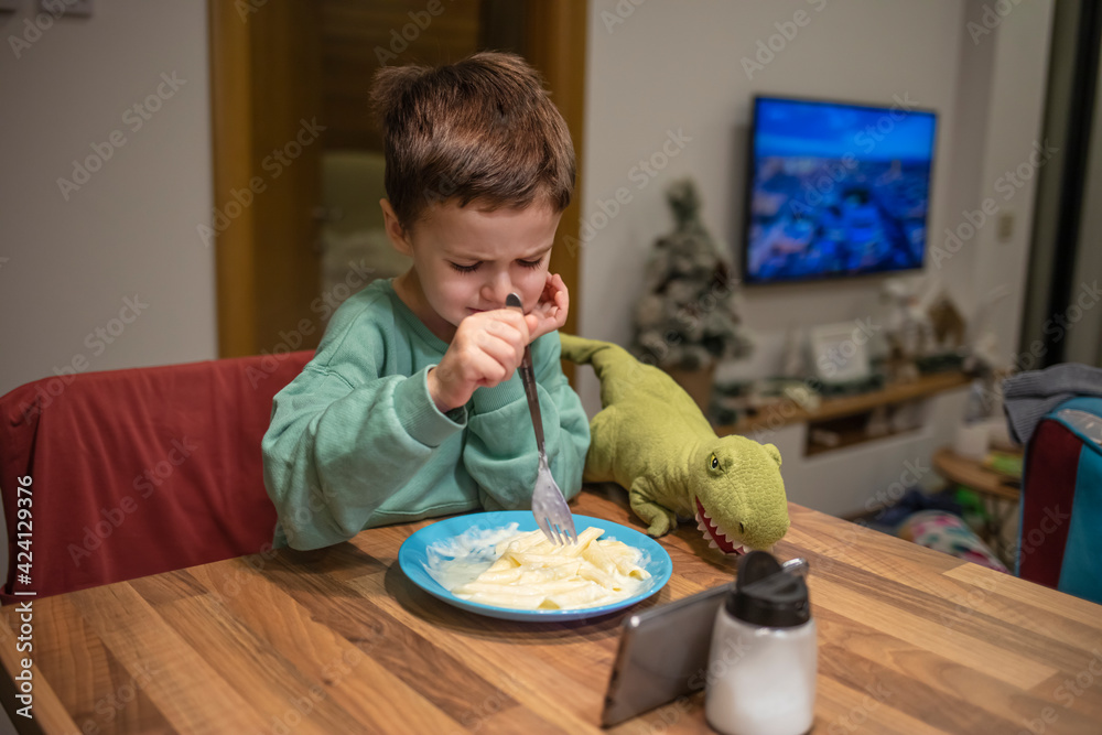 Boy unhappy with his lunch. Child boy eating boring food. Little boy is ...