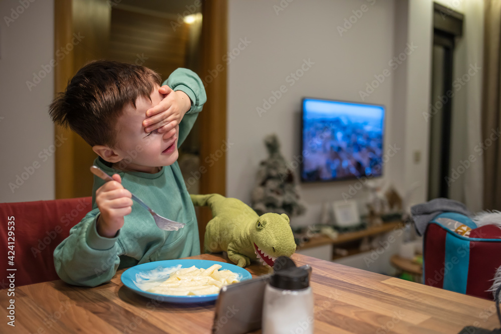 Boy unhappy with his lunch. Child boy eating boring food. Little boy is ...