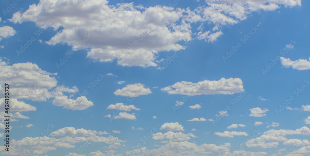 Blue sky with fluffy white clouds slightly purple tinged with sky ...