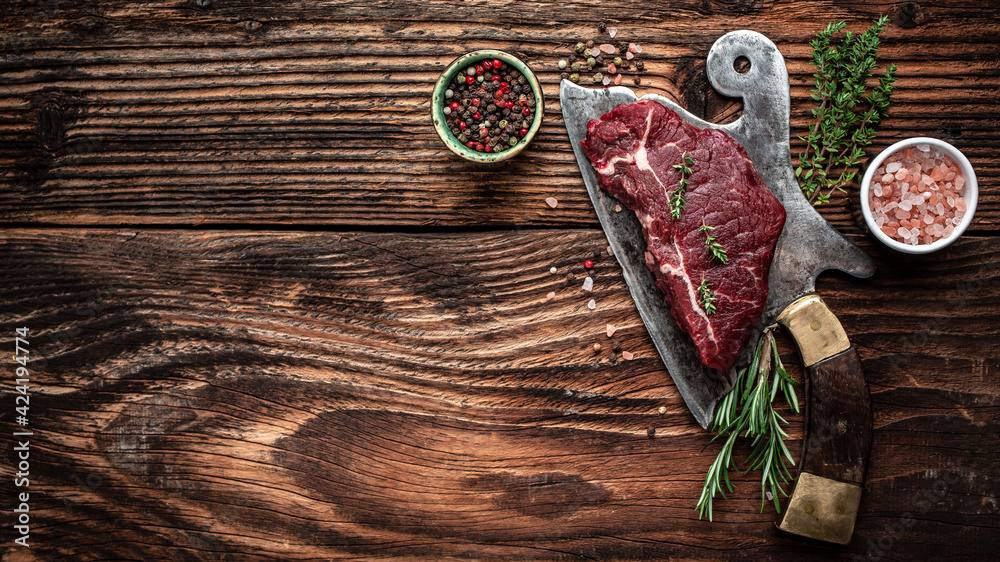 Raw rump steak on old meat cleaver on dark wooden background. banner ...