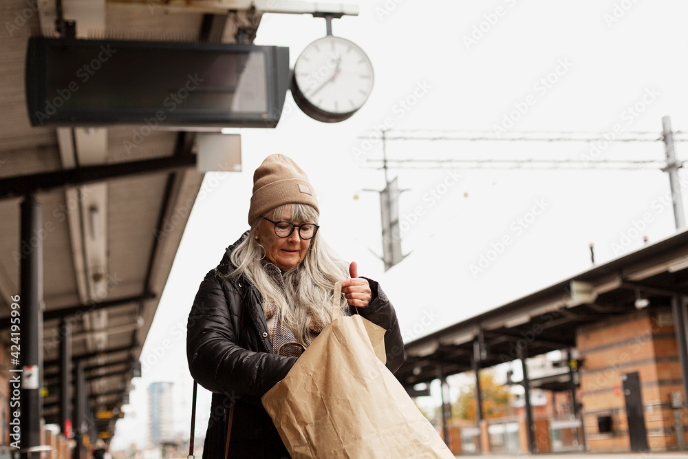 Mature woman at train station Stock Photo | Adobe Stock