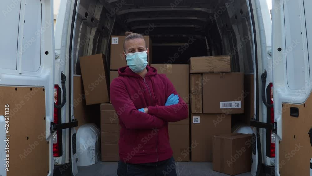 Portrait of a young man shipper with his van during the delivery round ...