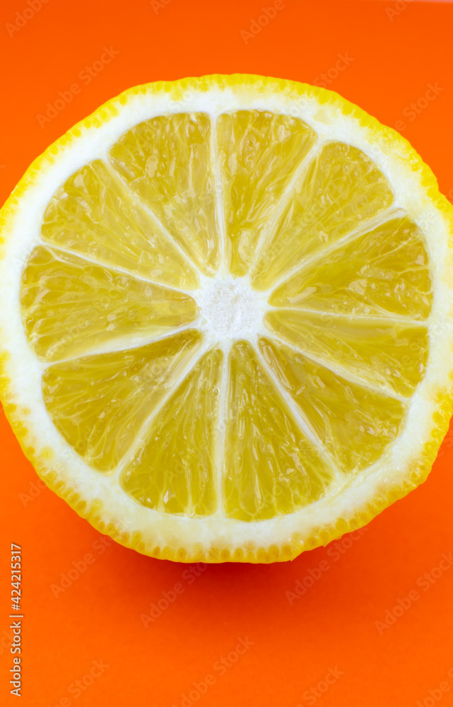 Close up photo of lemon texture on the orange background. Fruit cut in ...