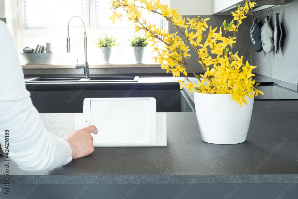 View of modern style kitchen. Mockup of a tablet with white blank ...