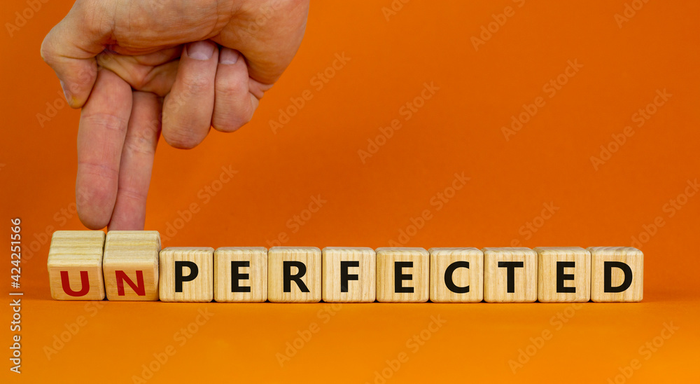 Perfected or unperfected symbol. Businessman turns wooden cubes and ...