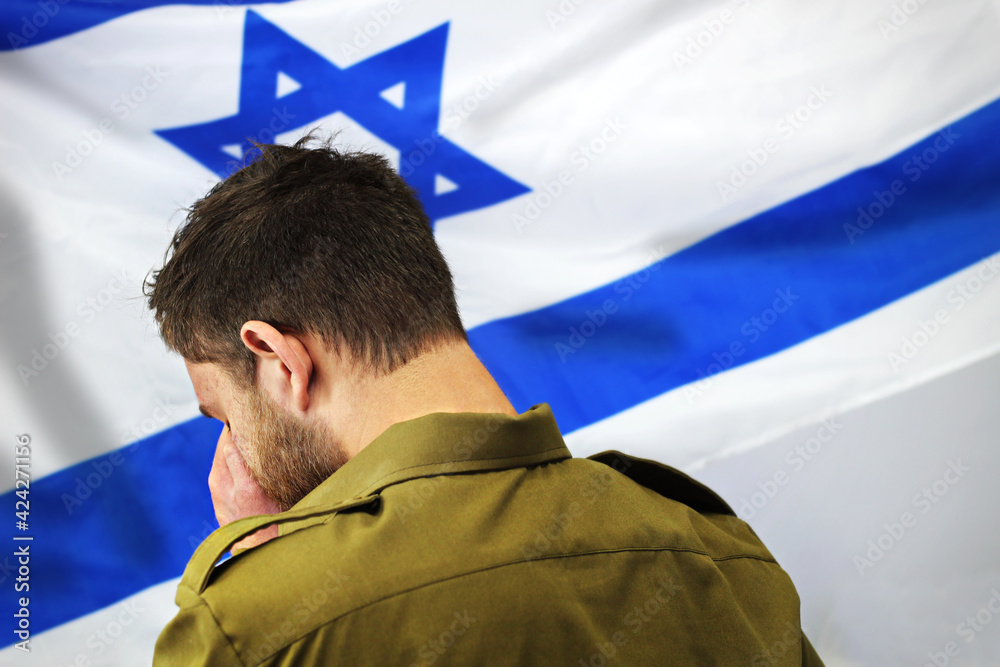 Israeli soldier crying in front of the flag of Israel Stock Photo ...