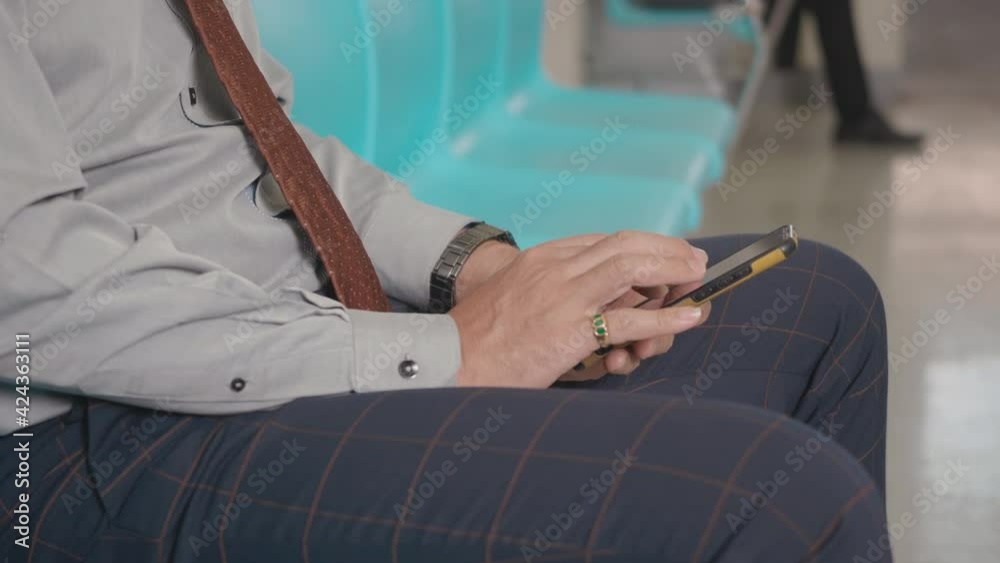 Close up businessman sitting on the seat using modern smartphone to internet checking news on ...