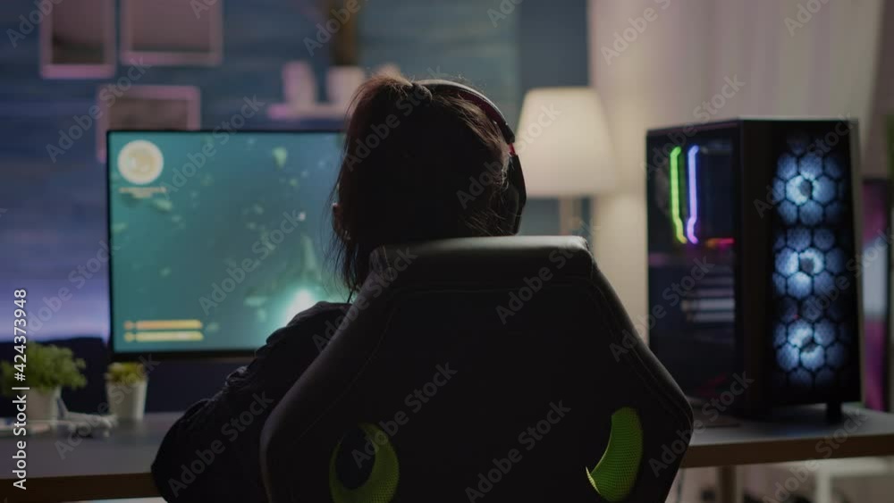 Back view of digital pro player playing online space shooter video game ...