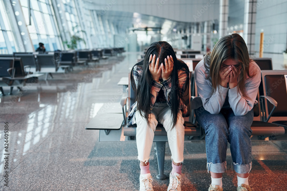 Sad young girl crying with her friend when sitting in the modern ...