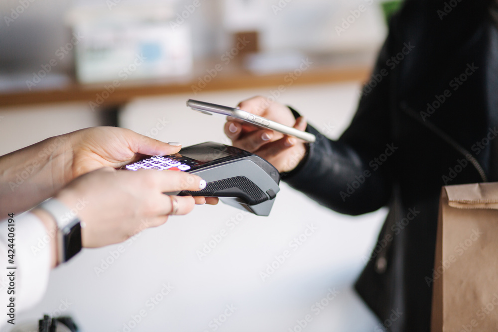 Closeup of female paying with smartphone during Covid-19 pandemic ...