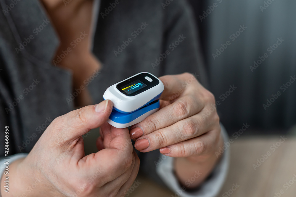 Old lady measuring her oxygen saturation with a pulse oximeter. Health ...