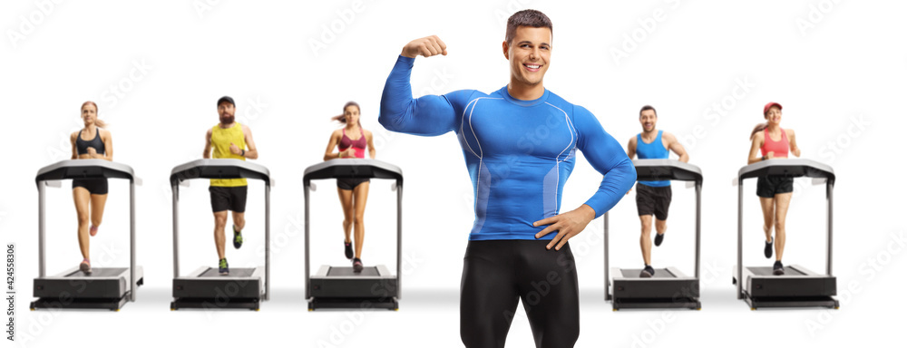 Bodybuilder flexing muscle and people running on treadmills in the back ...