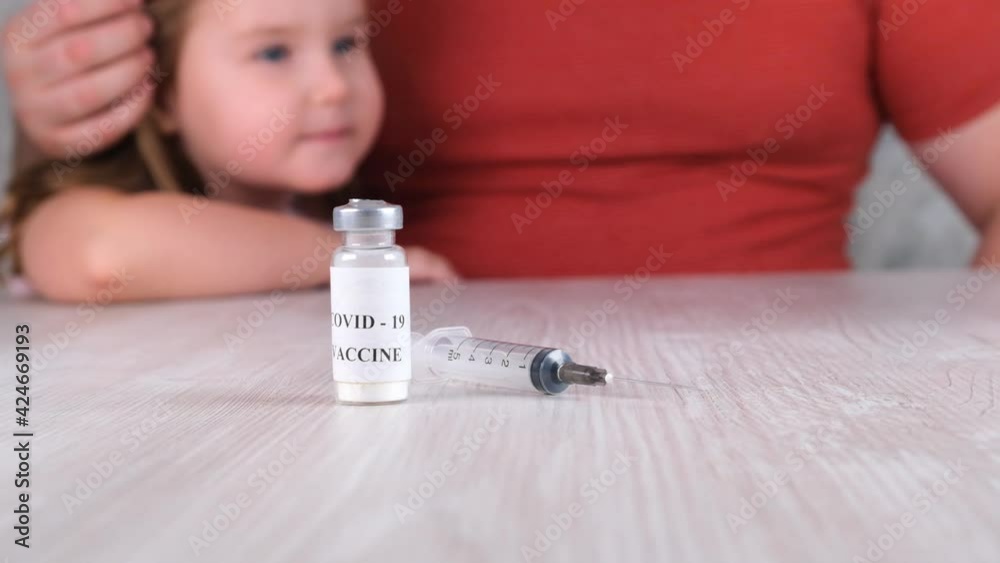 Little girl in the doctors office vaccinated. Syringe with vaccine ...