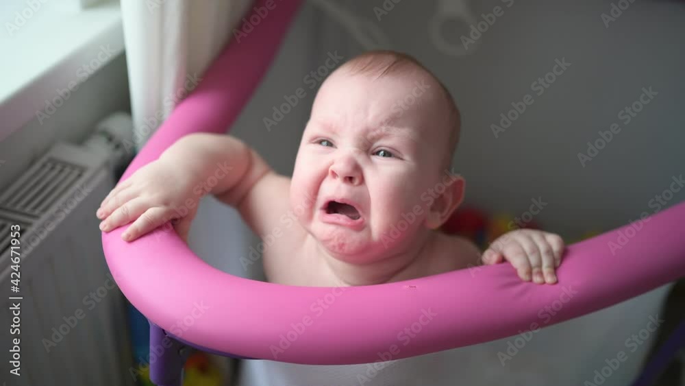 Cute emotional crying newborn little baby boy in pink playpen. Baby ...