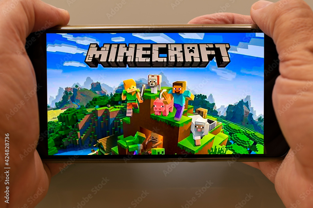 hands holding cell phone with Minecraft game application. Stock Photo ...