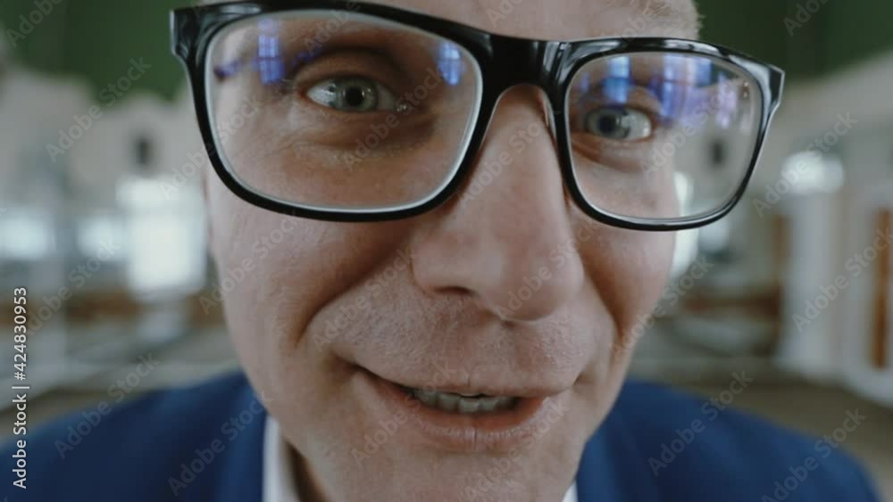 A young guy with glasses funny and emotional looks and speaks into the ...