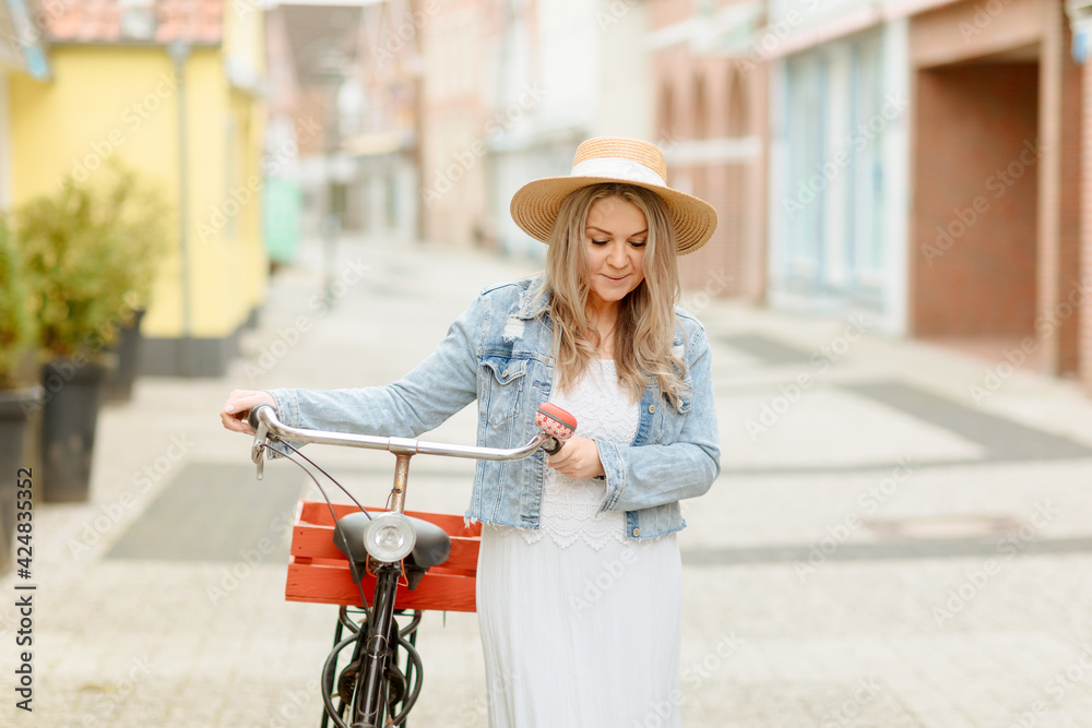 Sympathetic woman walks in the city center with her bike. Bicycle rails ...