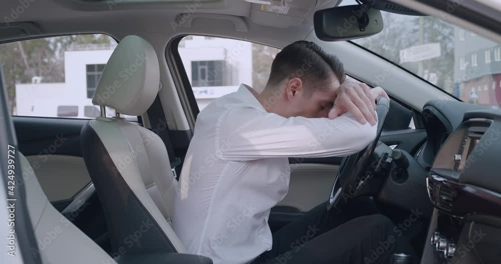 Sad male businessman crying while sitting in a car. Crisis and problems ...