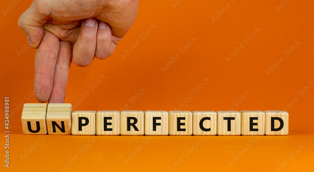 Perfected or unperfected symbol. Businessman turns wooden cubes and ...