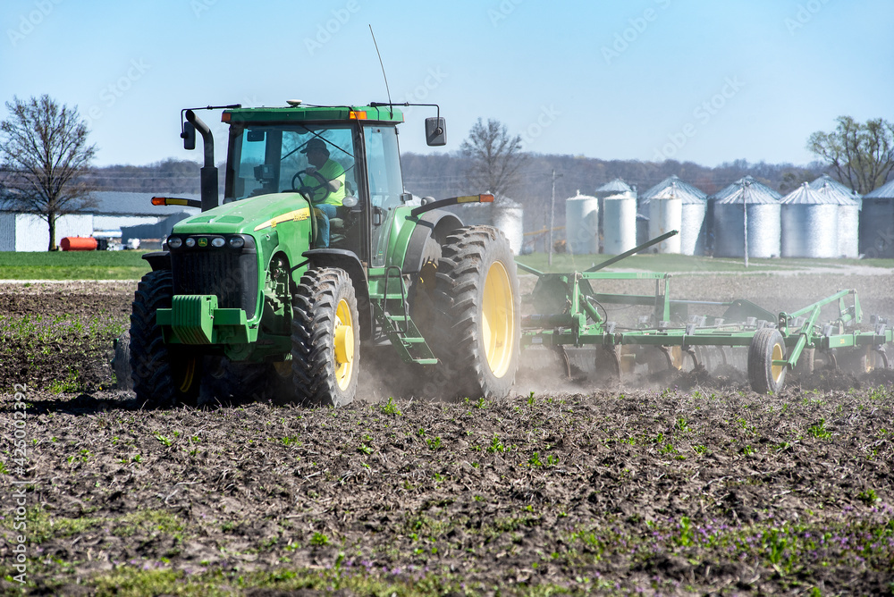 Illinois, USA, April 2, 2021 - Farmer in tractor plowing farm field ...