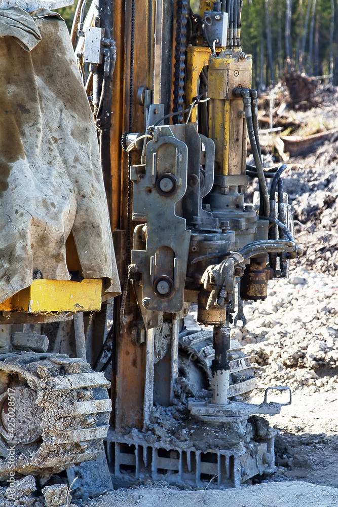 Mini-drilling rig on crawler track on site of sawn forest where large ...