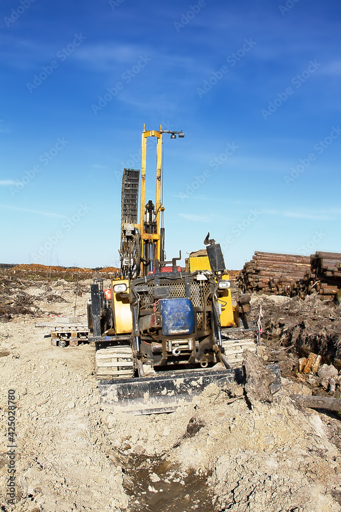Mini-drilling rig on crawler track on site of sawn forest where large ...